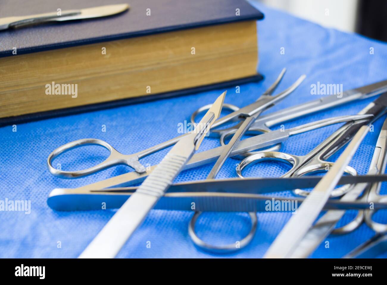 Closeup of a dissection kit on a blue surface with a book on it under ...