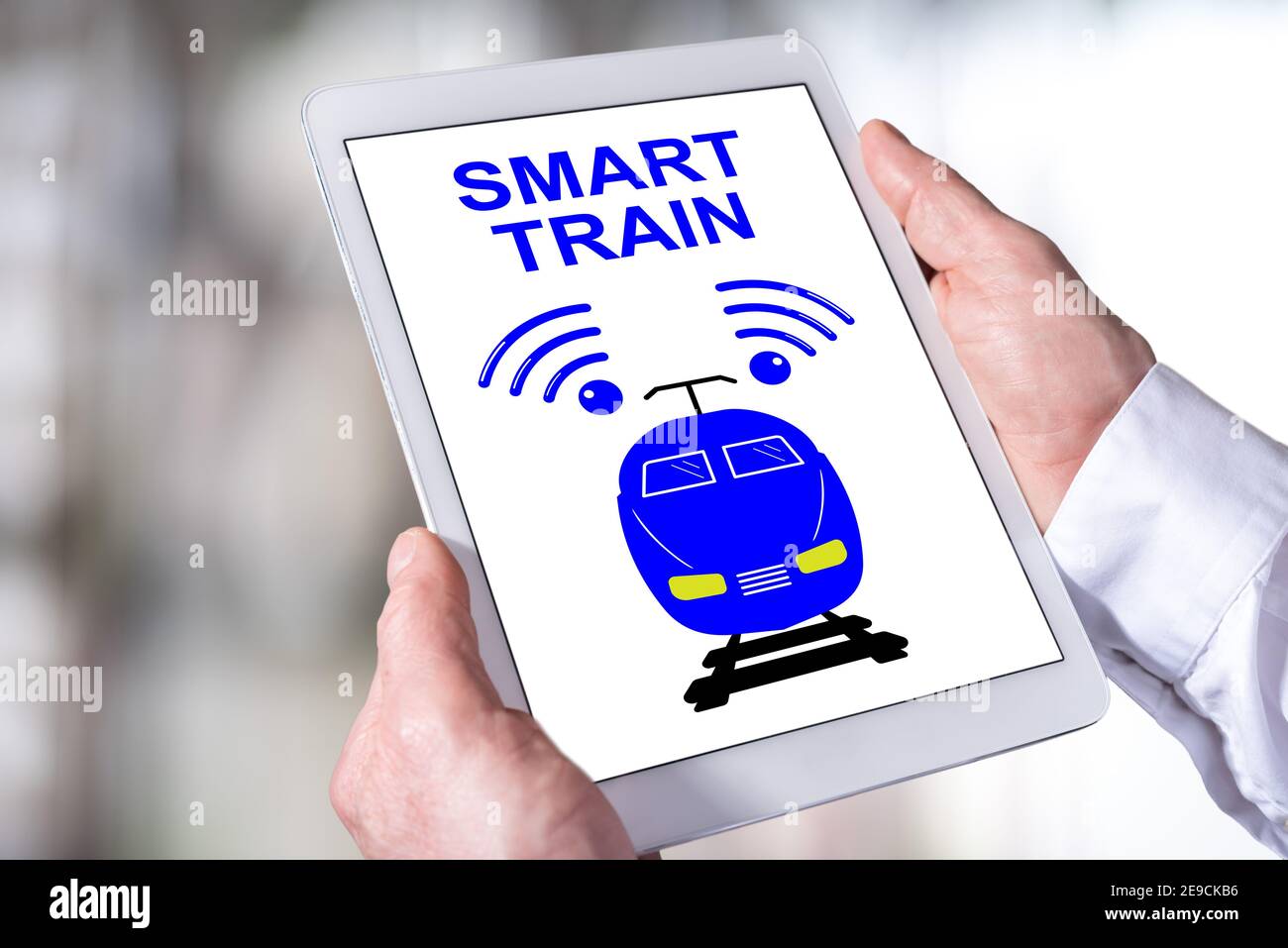 Man holding a tablet showing smart train concept Stock Photo - Alamy