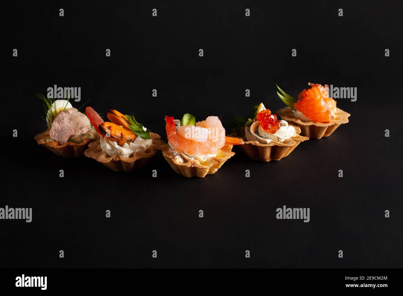 Seafood tartlets, studio photo. Shrimp salmon pate mussels, red caviar ...