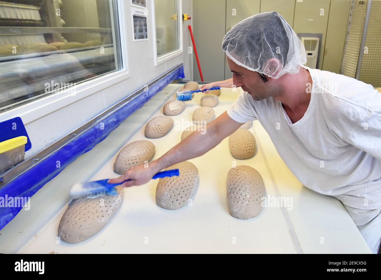 Worker in a large bakery - industrial production of bakery products on ...