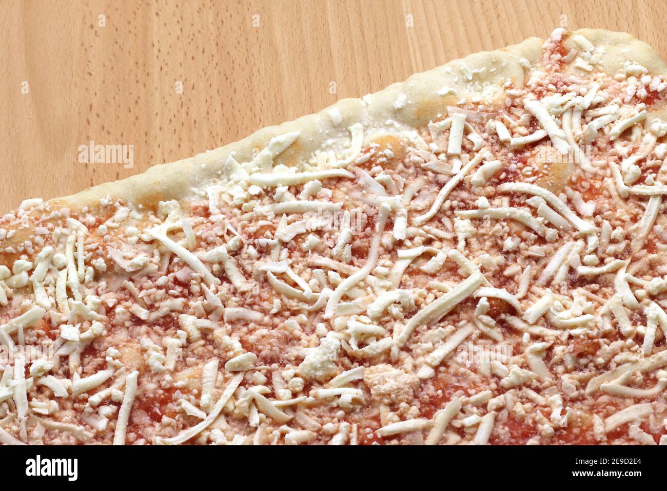 High angle shot of frozen rectangular pizza on a wooden table Stock ...