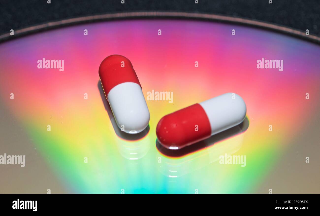 Closeup of the white and red medicine capsules on a rainbow background ...