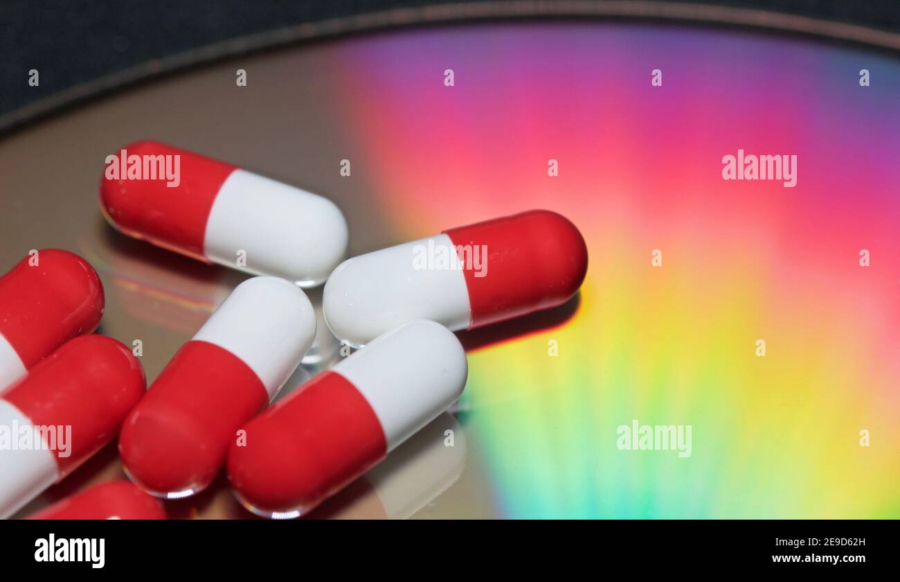 Closeup of the white and red medicine capsules on a rainbow background ...