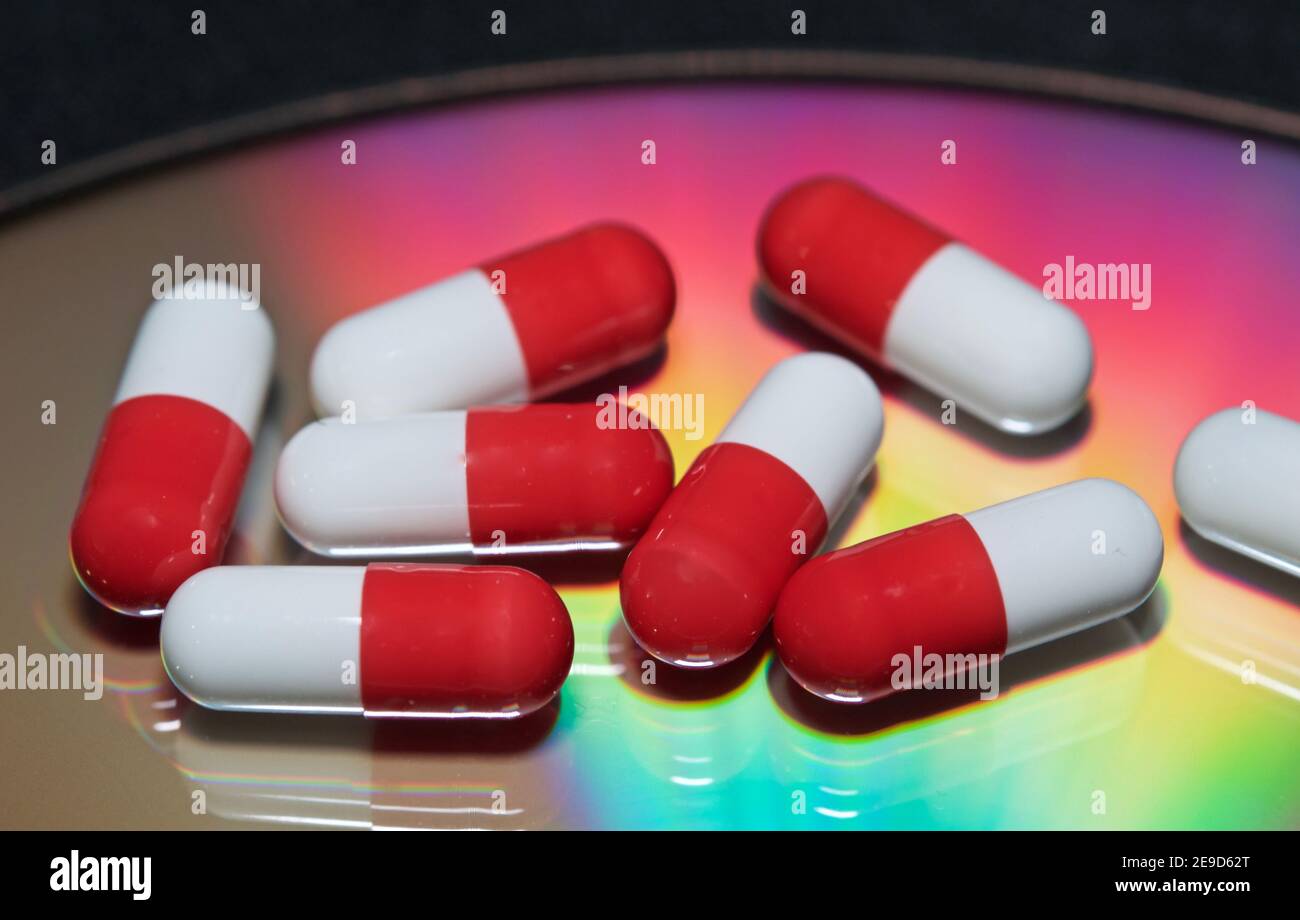 Closeup of the white and red medicine capsules on a rainbow background ...