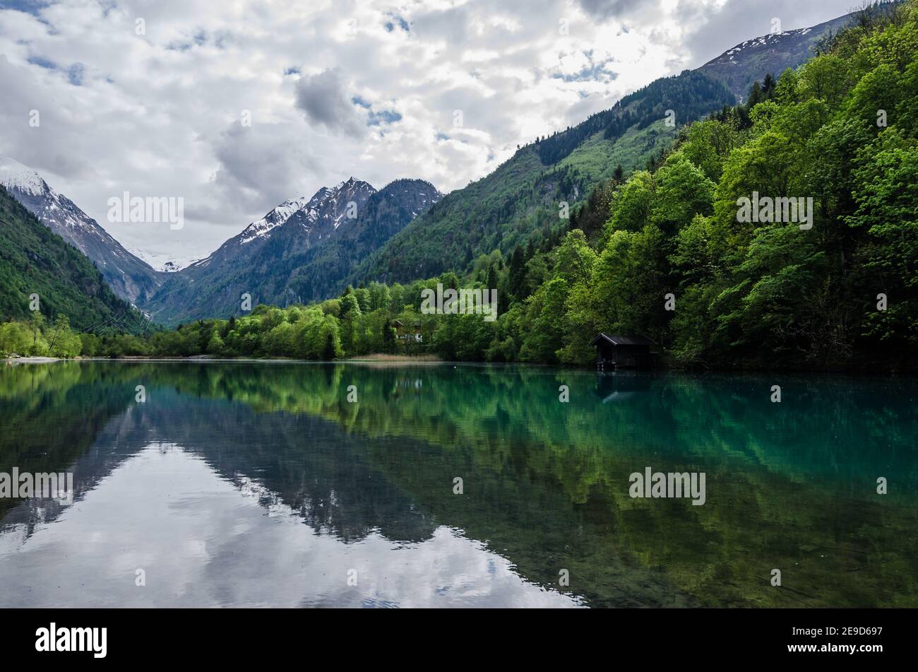 lake with reflection with mountains and green forest Stock Photo - Alamy