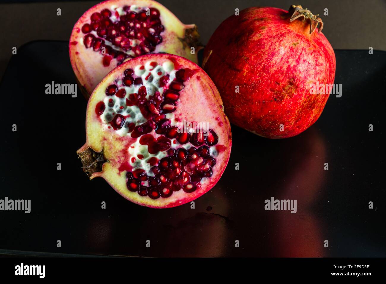 Three pomegranates in dark environment Stock Photo - Alamy