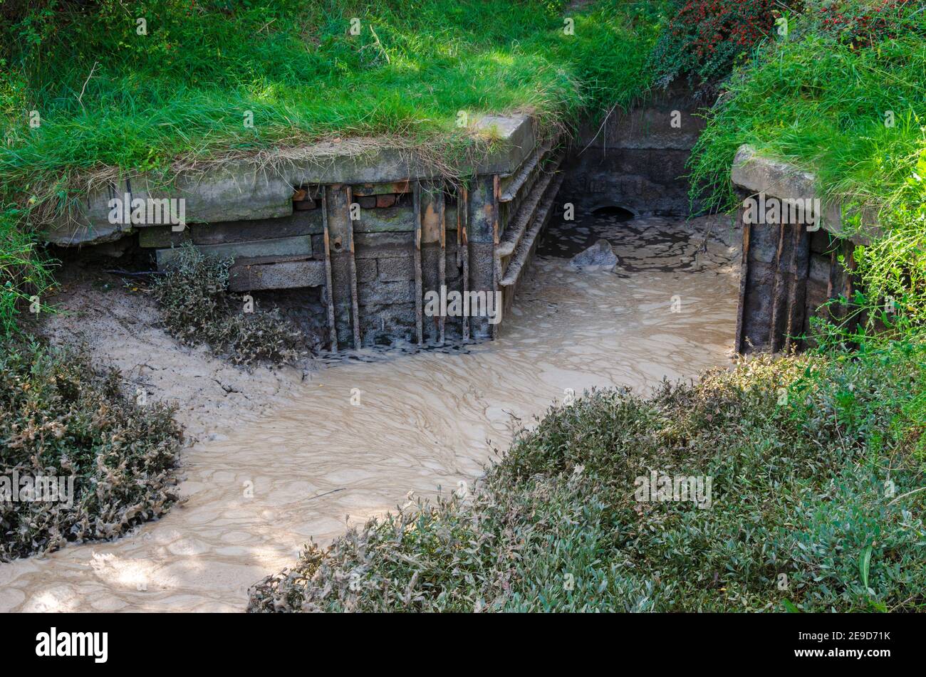 Water pollution is evident in the outflow of water from a sewage sluice ...