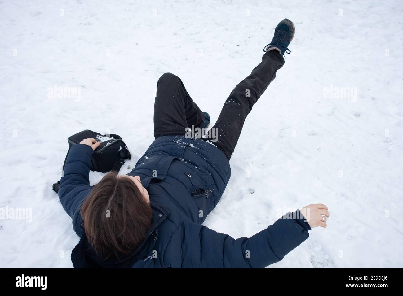 A man falls in the snow. The man slipped and was injured. Falling on ...