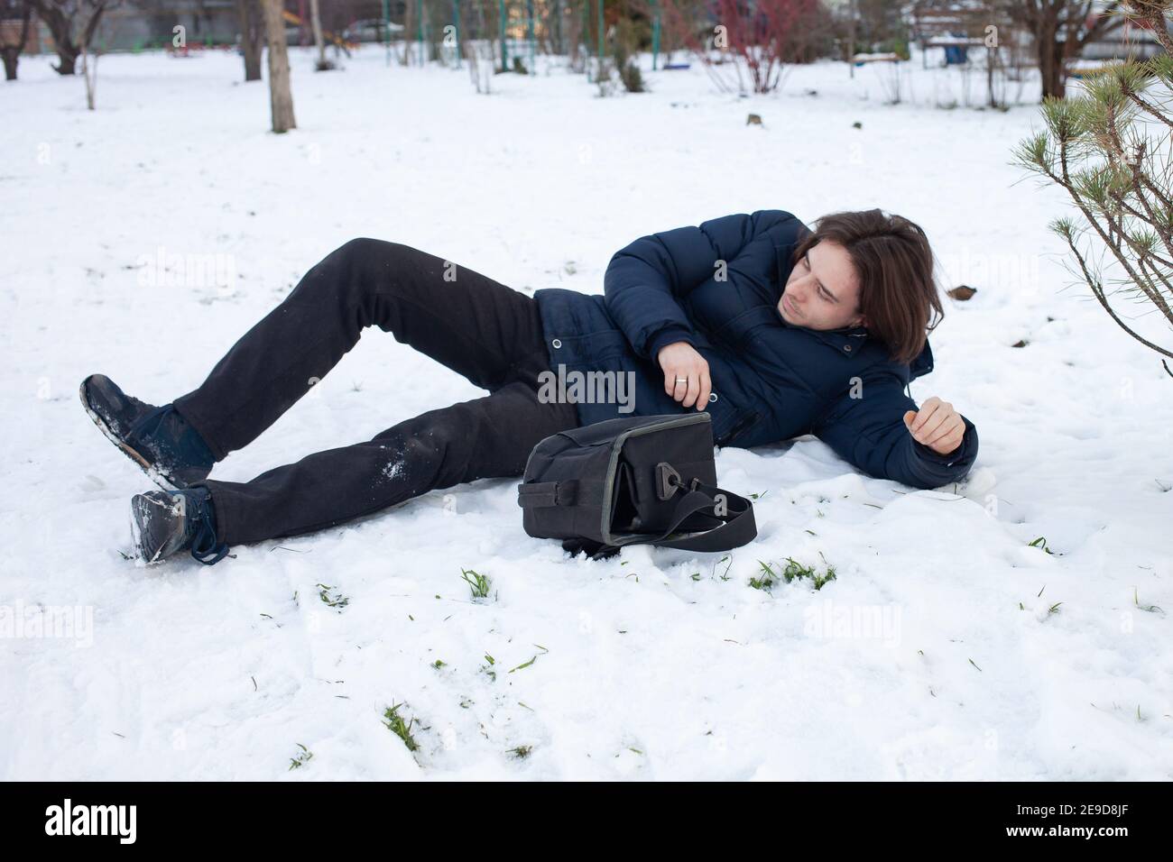 A man falls in the snow. The man slipped and was injured. Falling on ...