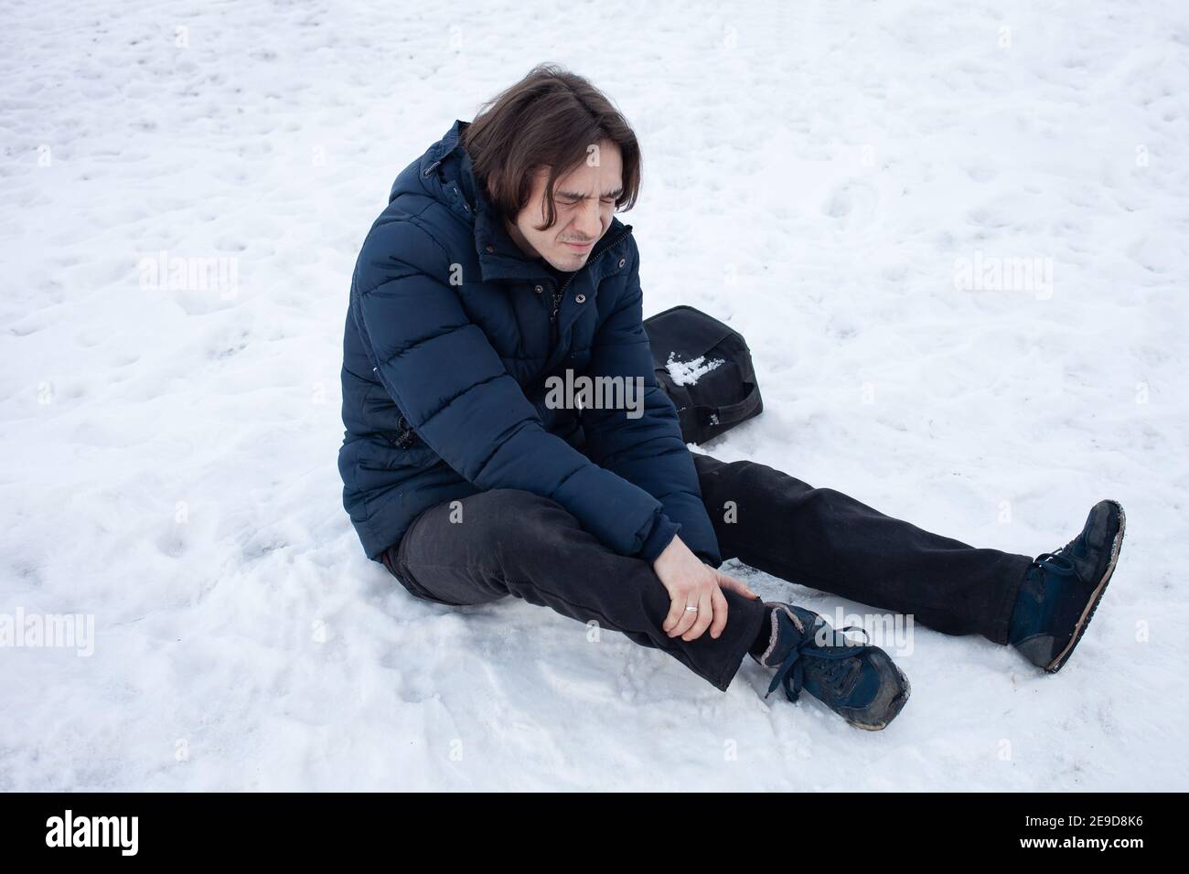 A man falls in the snow. The man slipped and was injured. Falling on ...