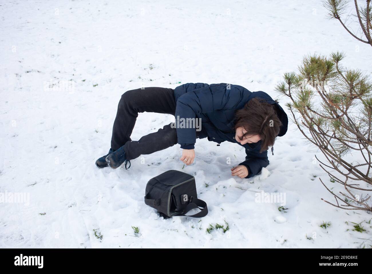 A man falls in the snow. The man slipped and was injured. Falling on ...