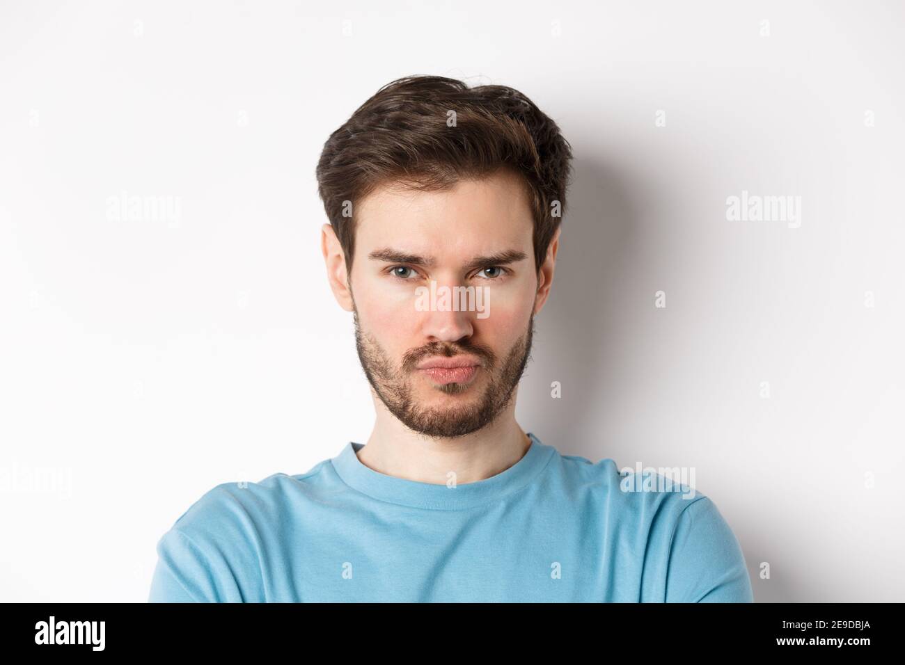 Close-up of grumpy young man grimacing, sulking and making offended ...
