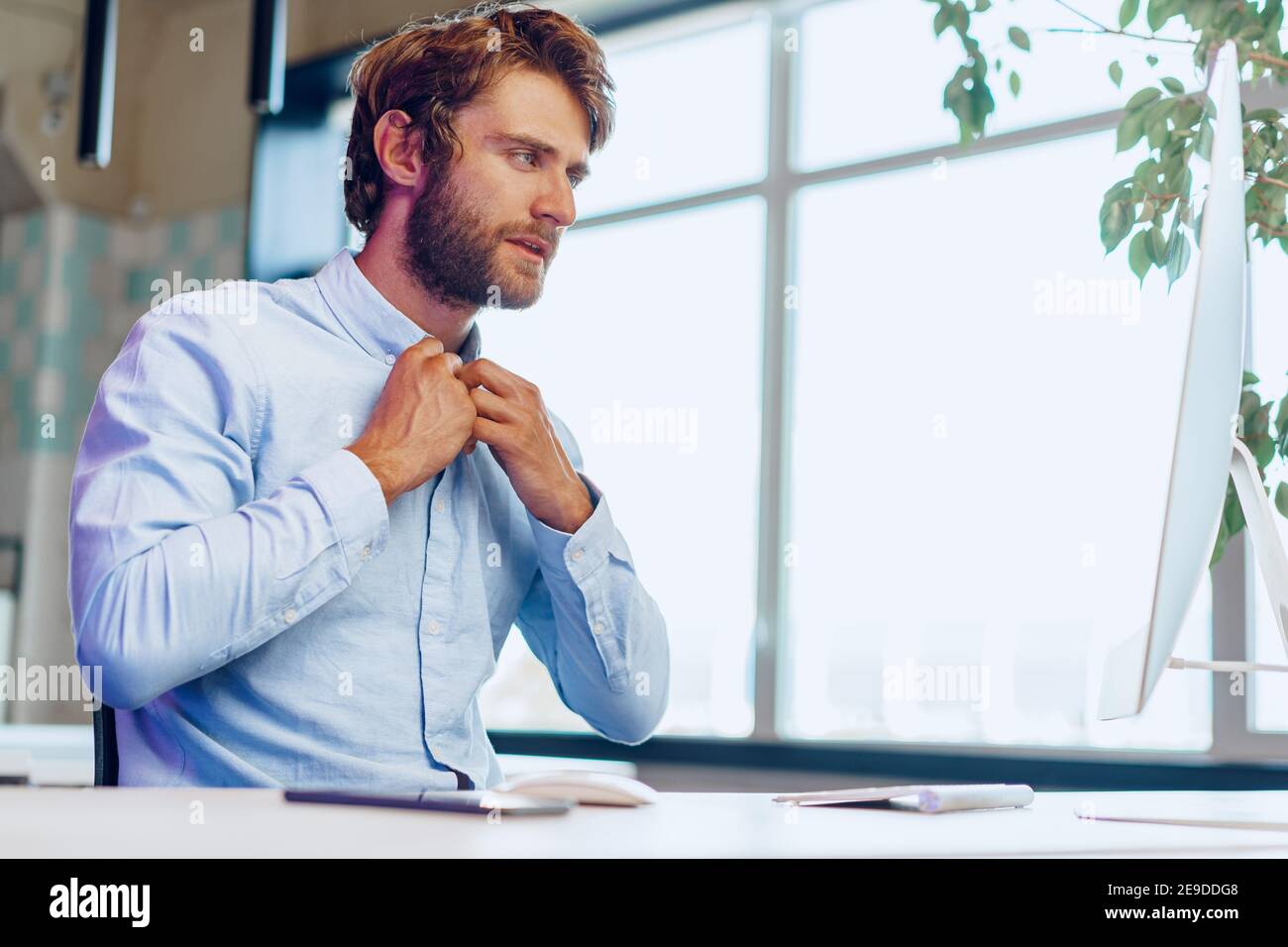Young bearded businessman using his computer in a modern office place ...
