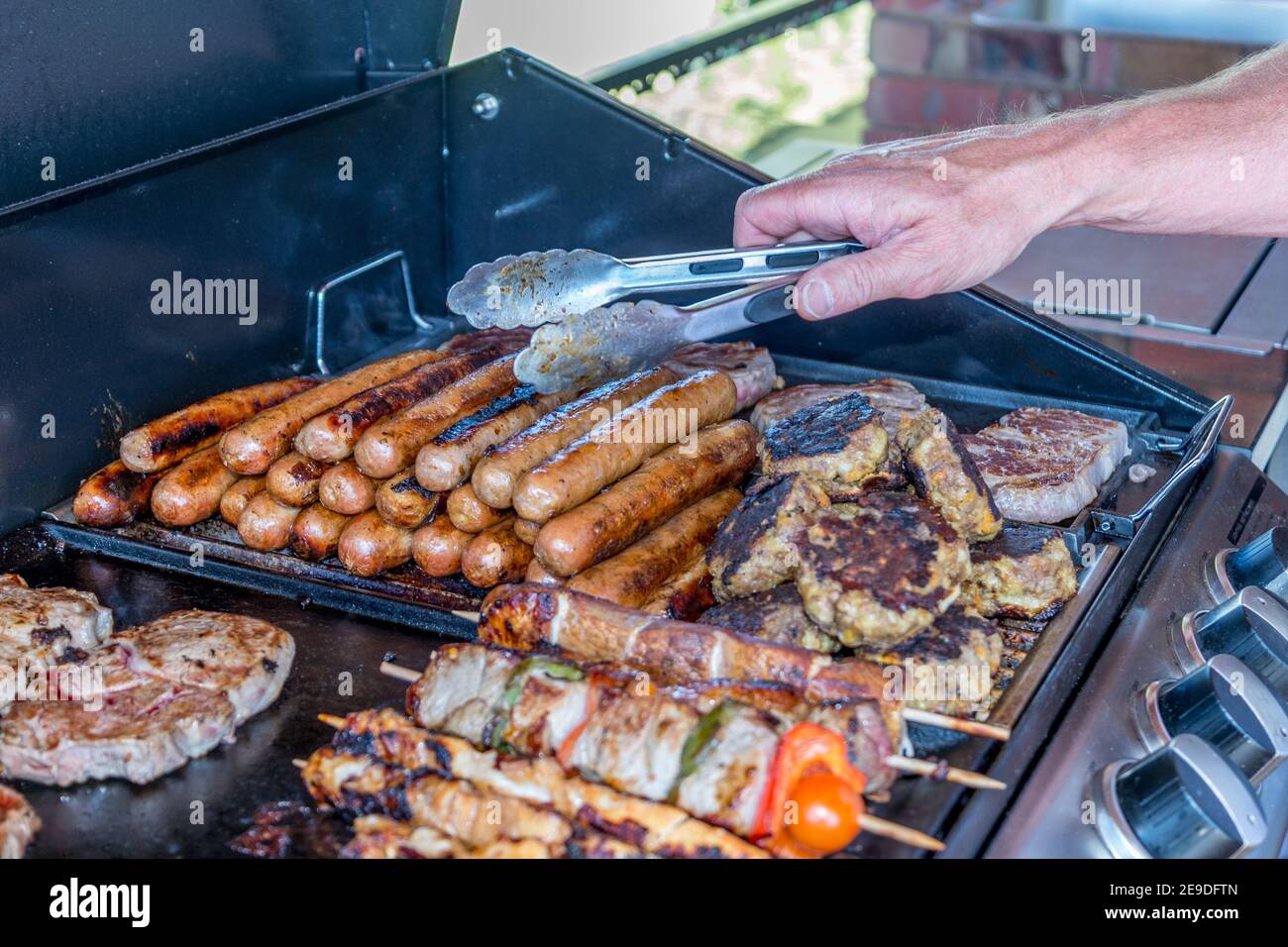 Person preparing a barbeque with lots of meat Stock Photo - Alamy