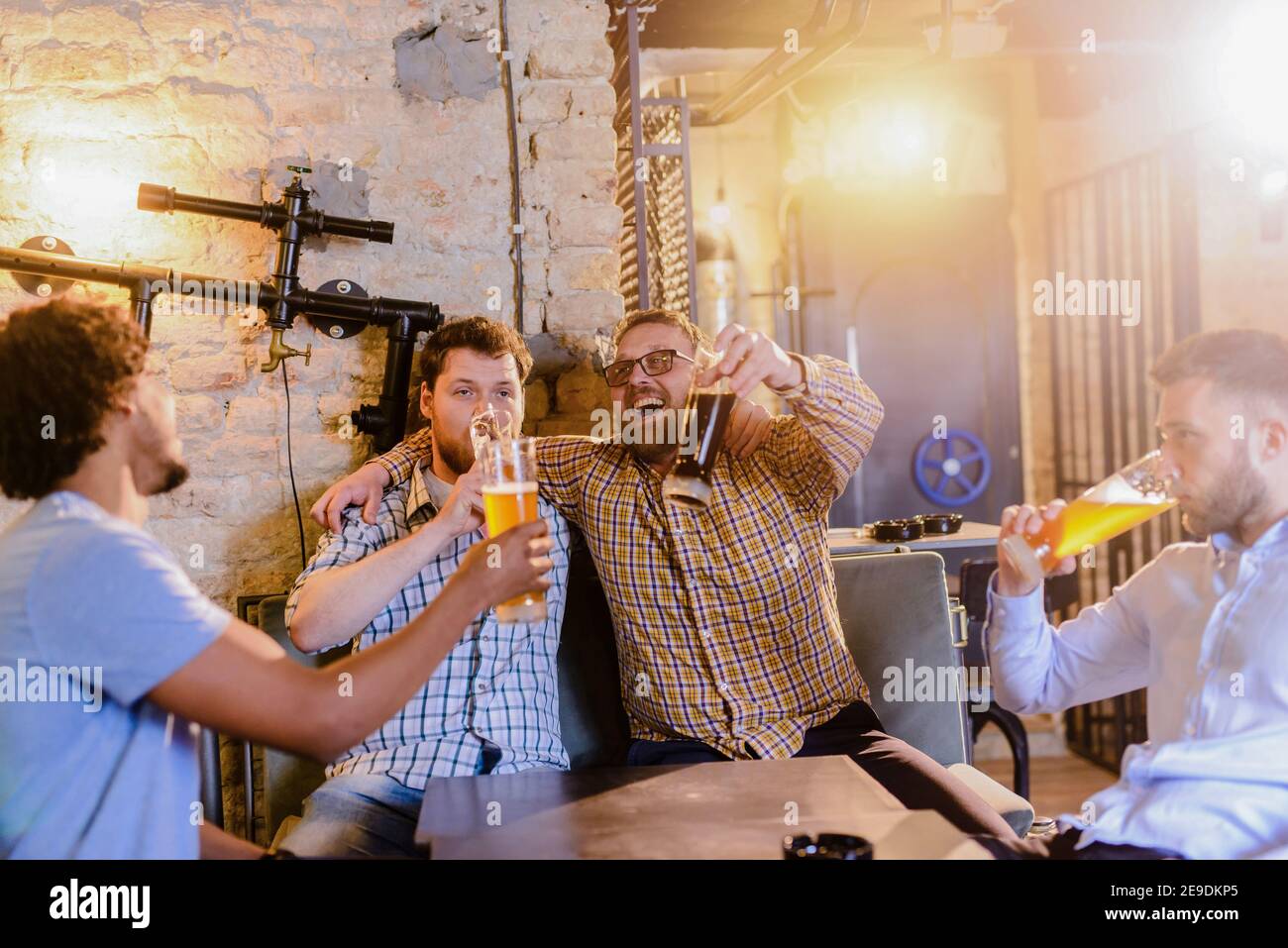 Happy drunk male friends sitting in a bar and having fun Stock Photo ...