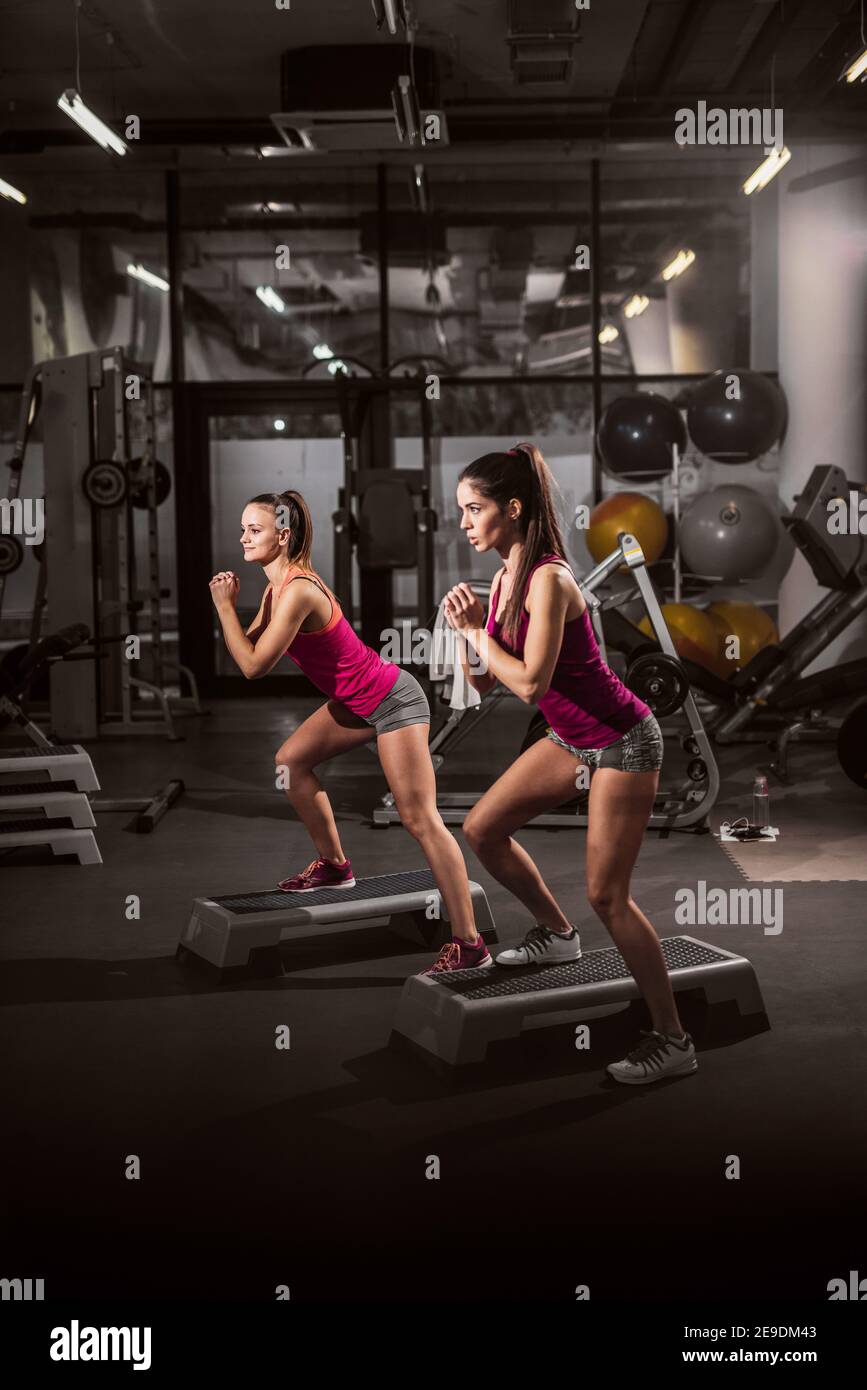 Two attractive women exercising on stepper in gym. Healthy lifestyle ...