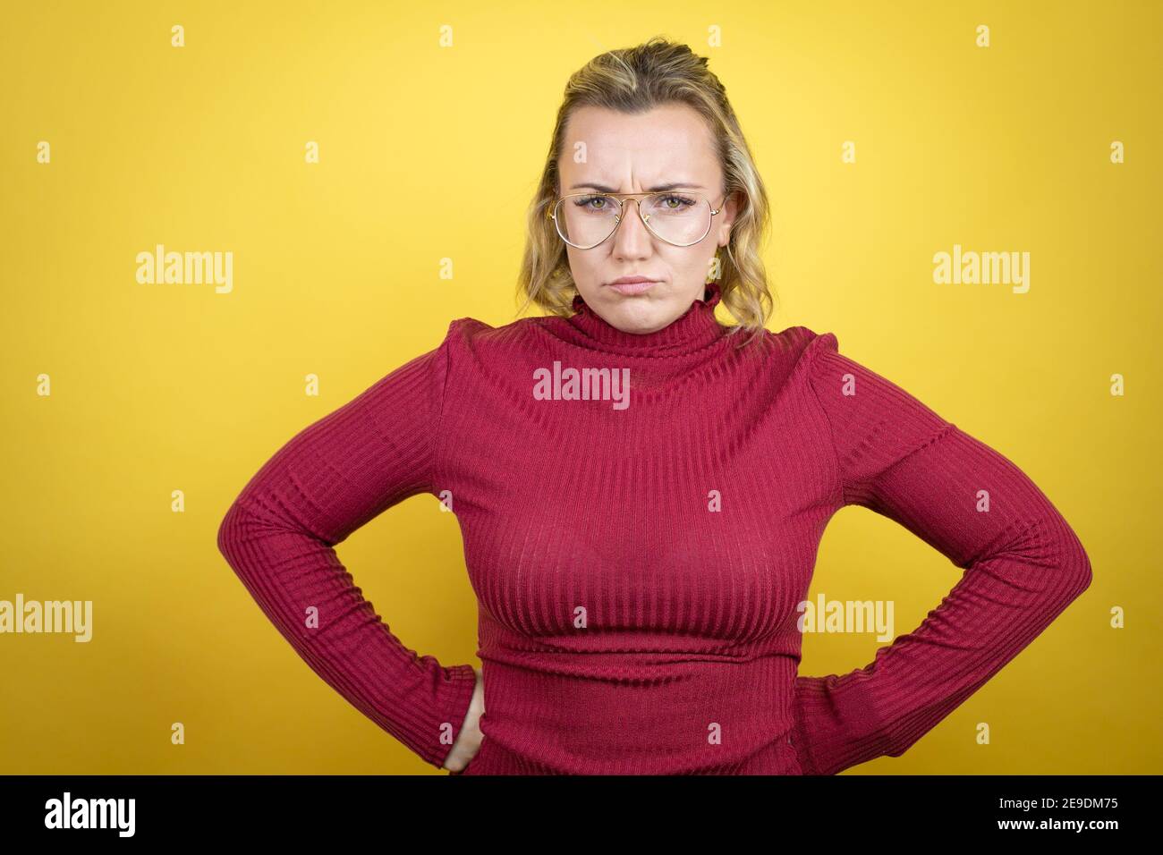 Young caucasian woman wearing casual red t-shirt over yellow background ...