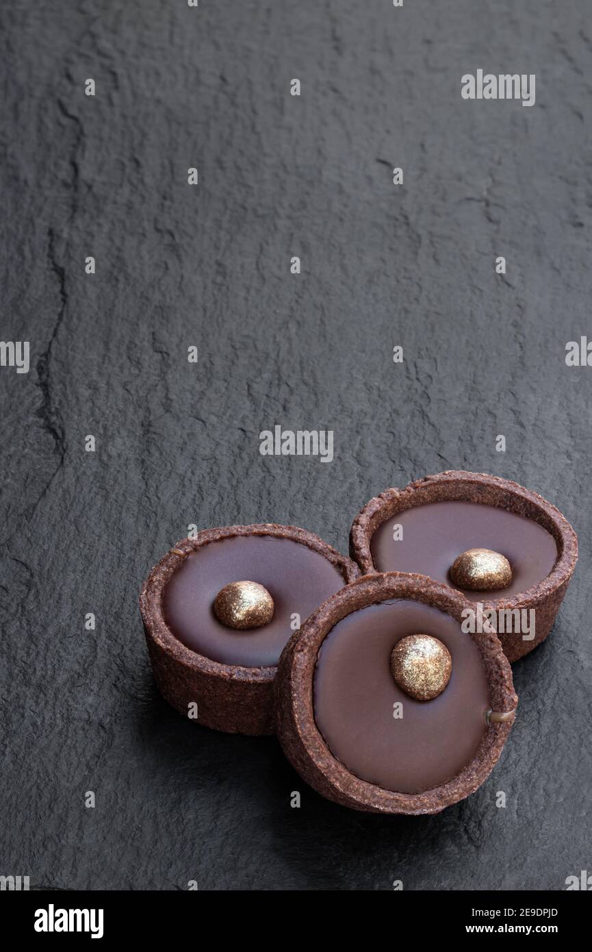 Molten Chocolate Caramel truffles decorated with golden drip on stone ...