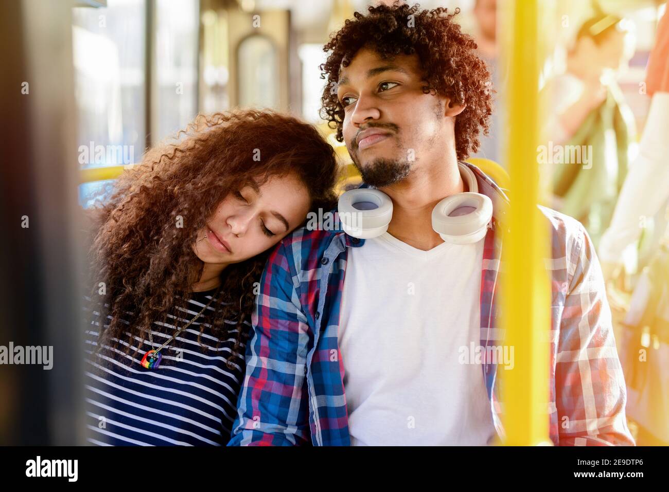 Picture of cute young couple sitting in a bus. Girl leaned her head on ...