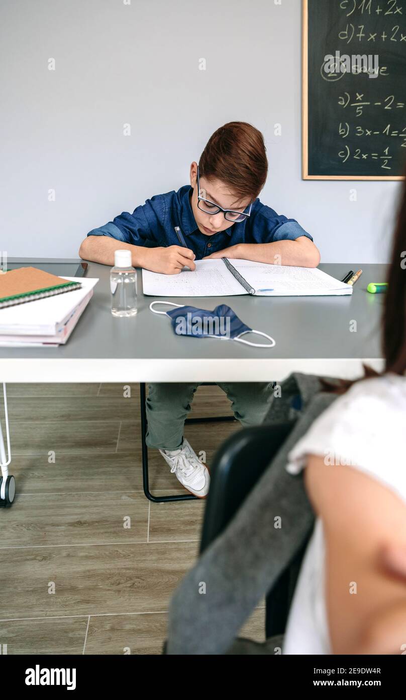 Boy writing in his notebook at school Stock Photo - Alamy