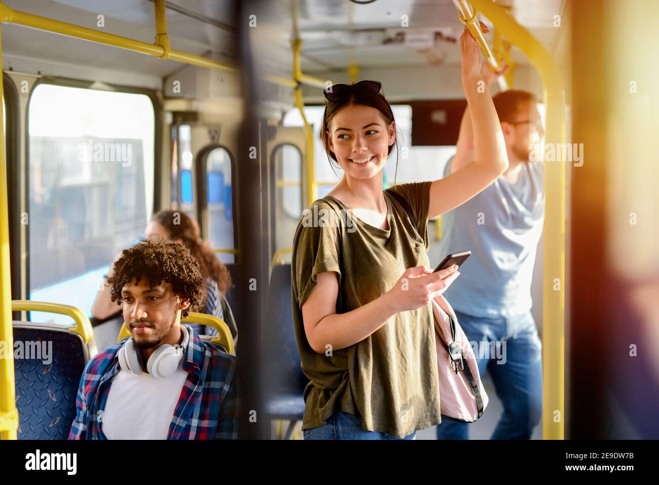 Modern smiling cute girl standing in a bus . Smiling and looking away ...
