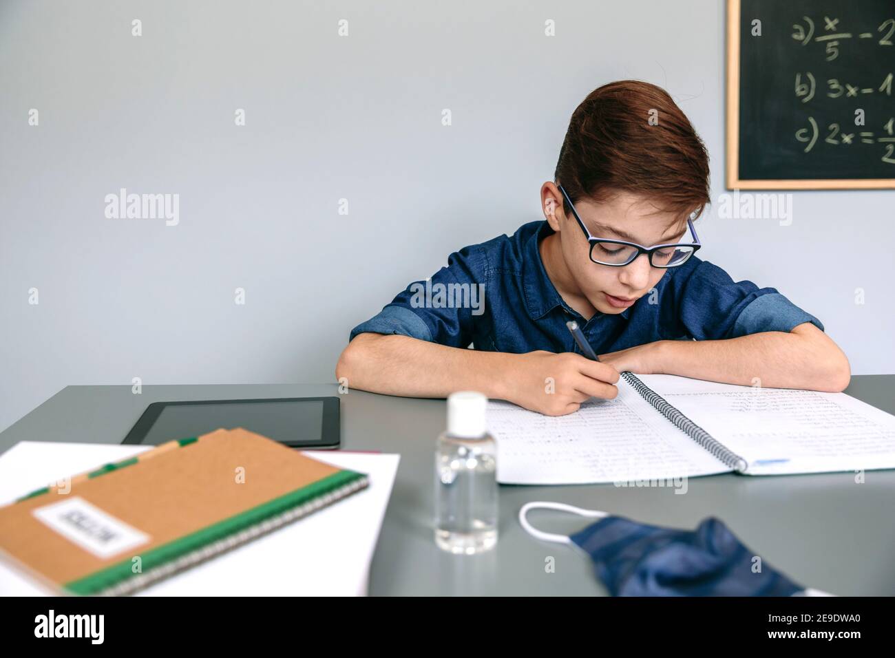 Teen boy writing classroom hi-res stock photography and images - Alamy