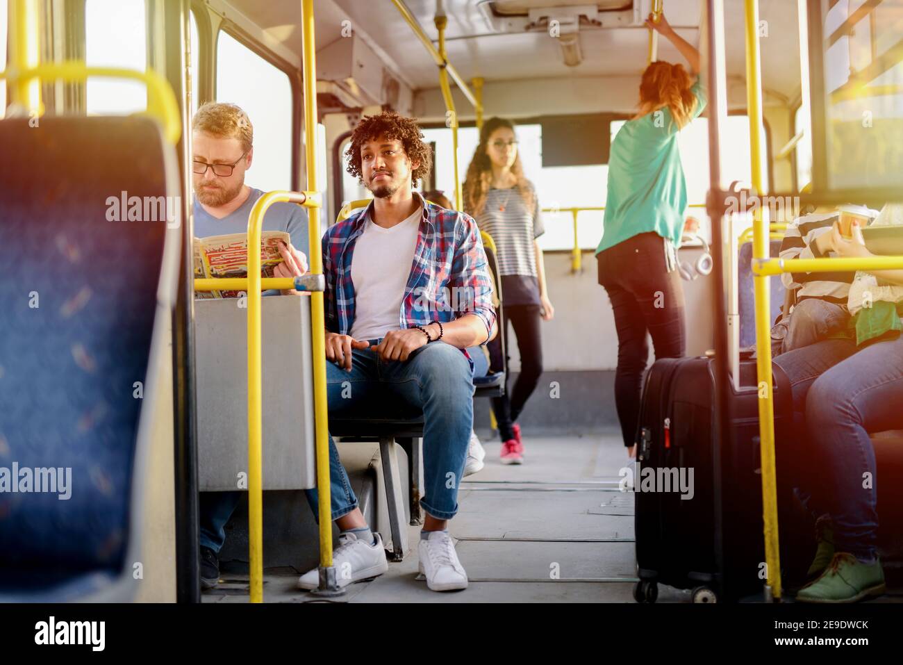 Picture of people sitting and standing in a bus Stock Photo - Alamy