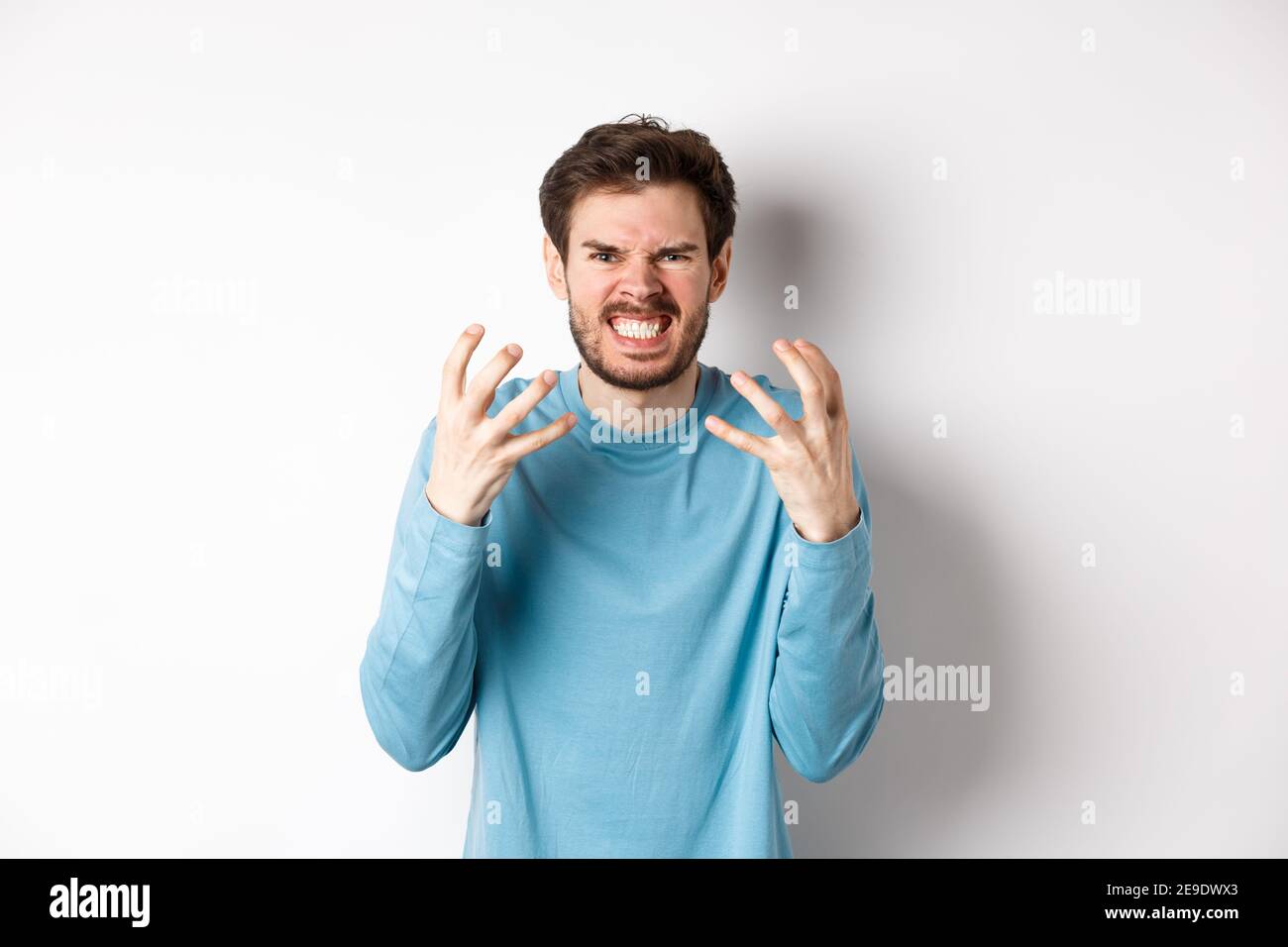 Angry caucasian man shaking hands and grimacing, looking with mad face ...
