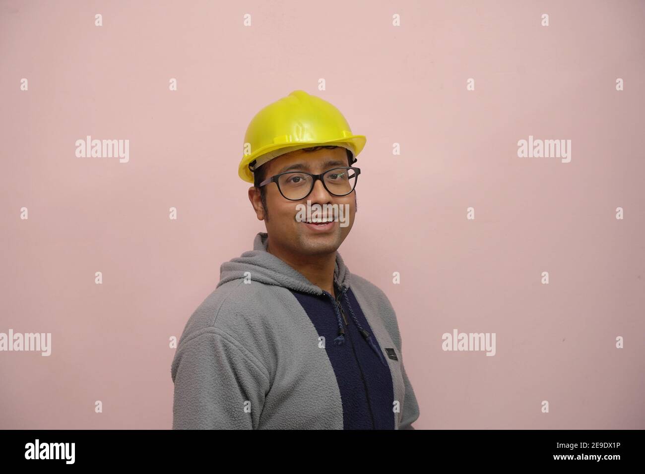 Portrait of an Indian engineer wearing a yellow safety helmet while ...