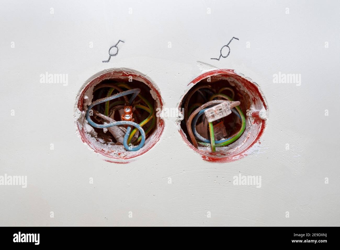 Electric cables sticking out of an orange box placed in the wall of the ...