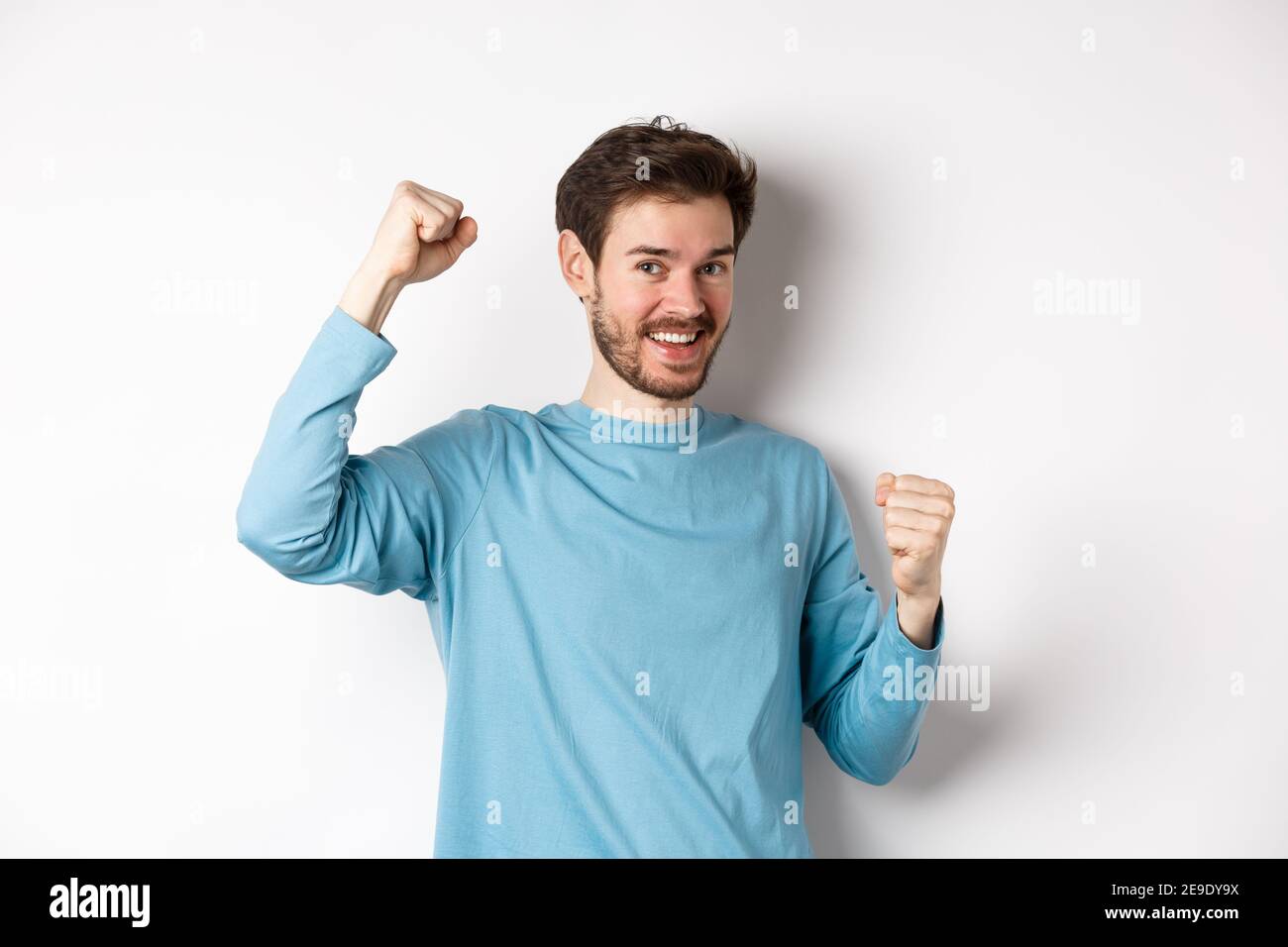 Happy bearded man celebrating victory, raising hands up and triumphing ...