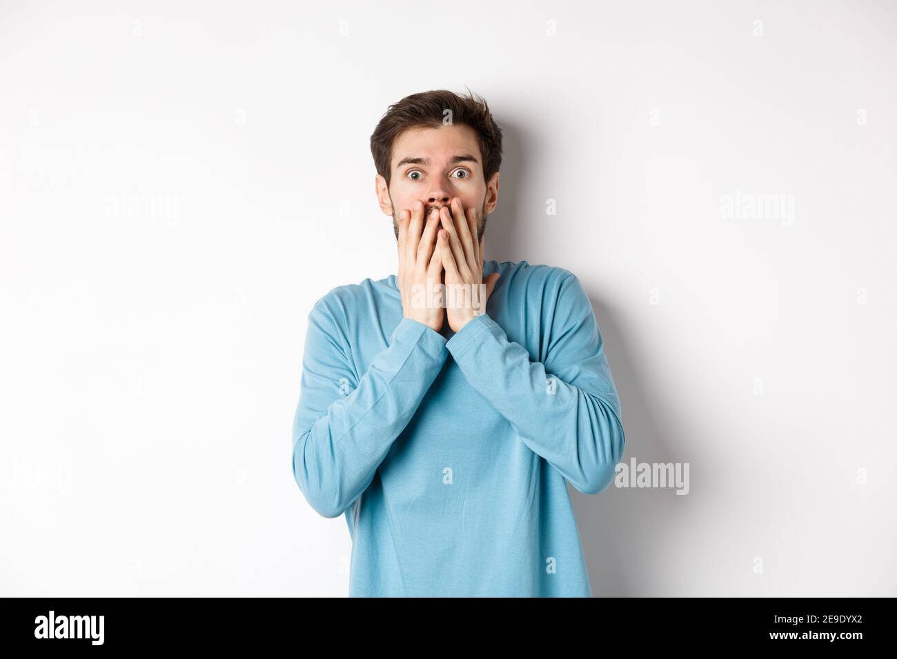 Shocked and startled cauacasian man, gasping and covering mouth with ...
