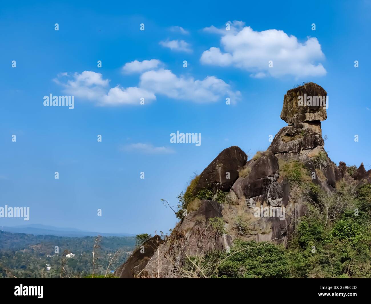 Beautiful view of a rocky cliff surrounded by greens gleaming under the ...