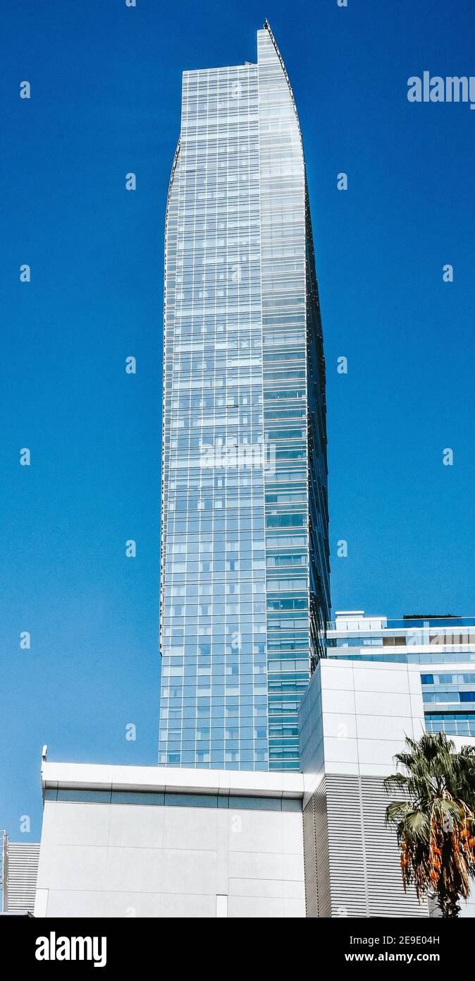 Vertical panoramic view of a high-rise modern building with a blue ...