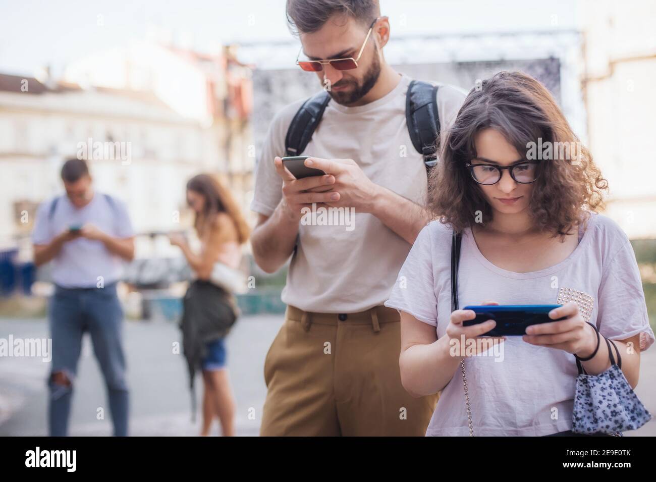Group of friends using smartphones together. Young people addiction to ...