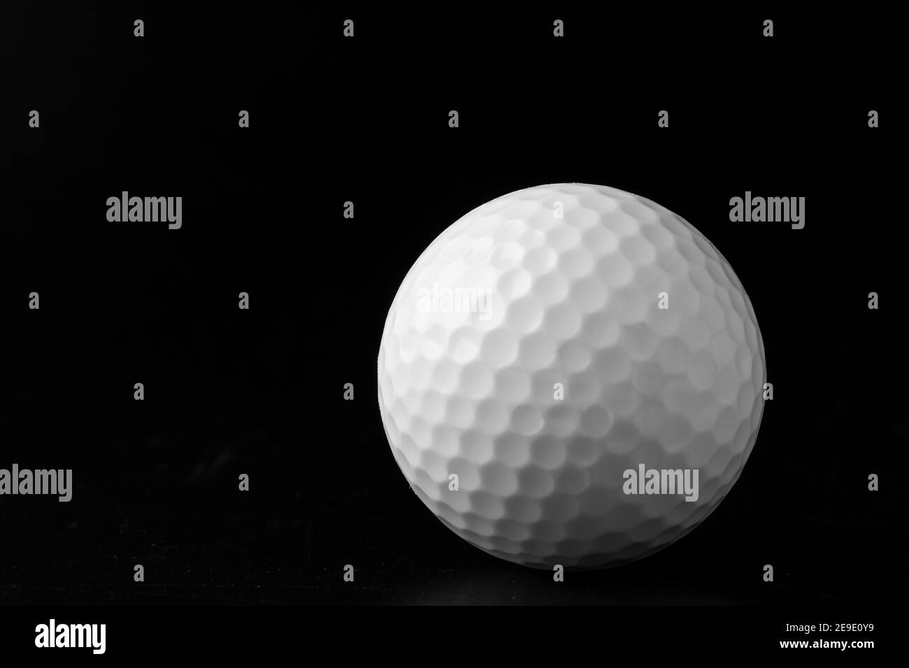 Golf ball close up on black background Stock Photo - Alamy