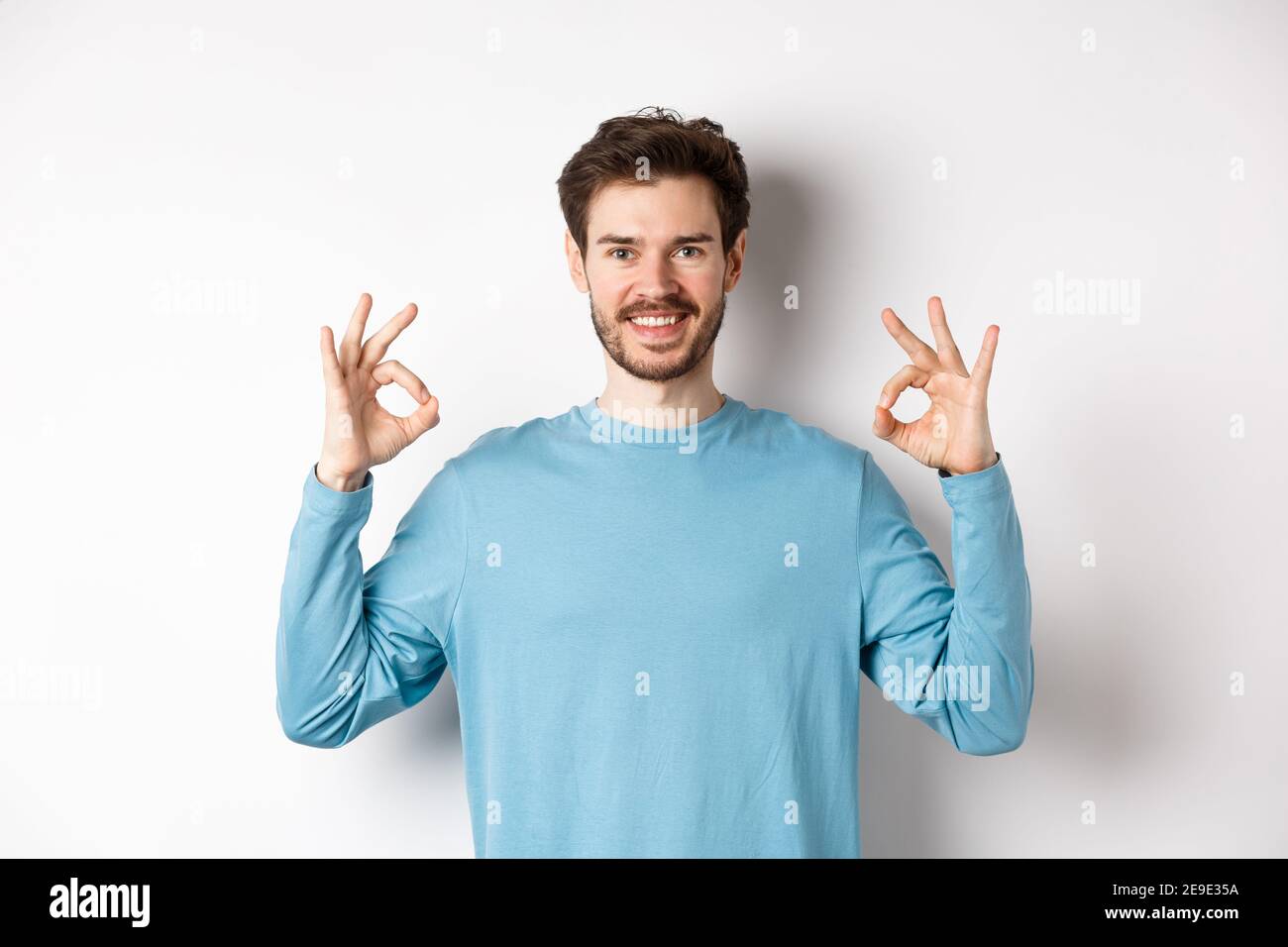 Very good. Smiling handsome guy showing okay signs and looking ...