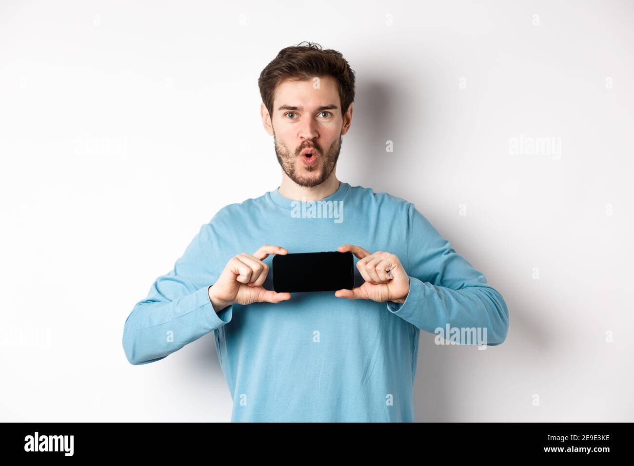 E-commerce and shopping concept. Image of impressed man saying wow and ...