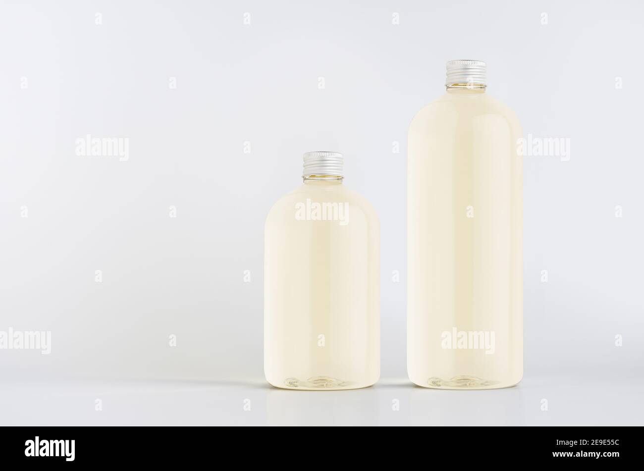 Set of two plastic tall and low bottles with pale fresh drink or ...