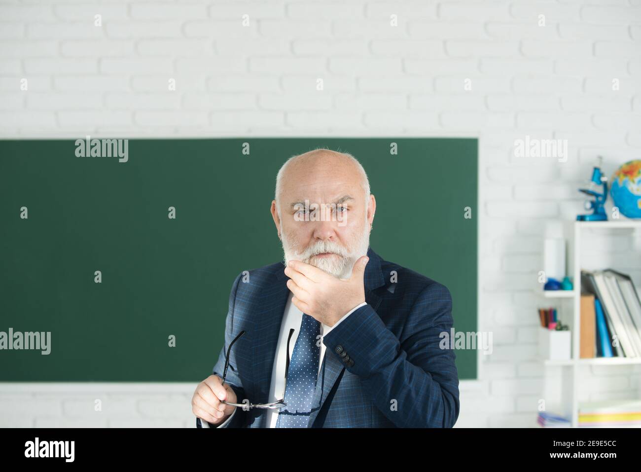 Old male teacher. Senior professor with gray hair in college. Think ...