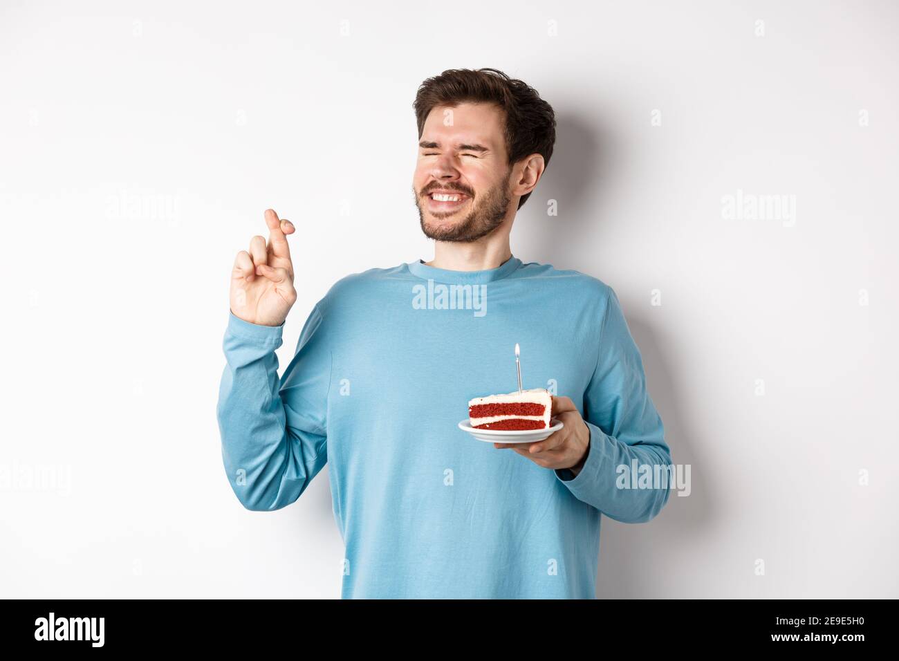 Celebration and holidays concept. Young man celebrating birthday, cross ...