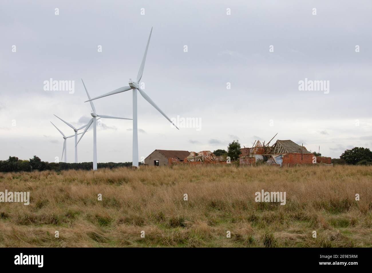 derelict and deserted farm buildings. Farmland with wind turbines and ...