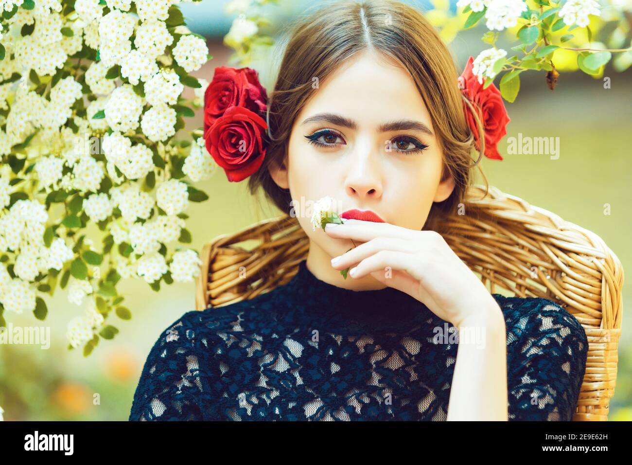 Thoughtful spanish girl with white flower in hand. Outdoor portrait of ...