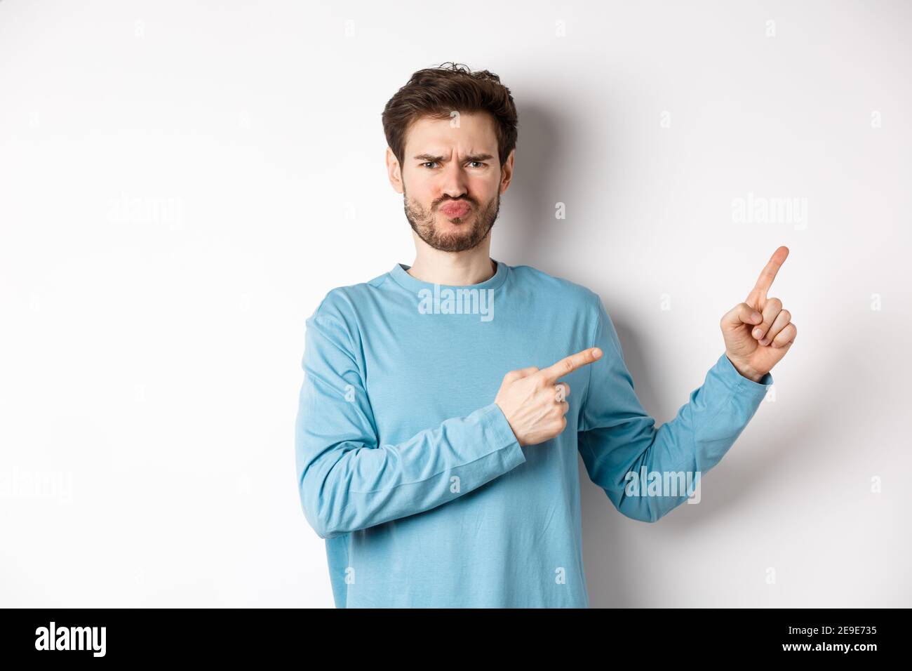 Disappointed and upset young man showing bad offer, pointing fingers ...