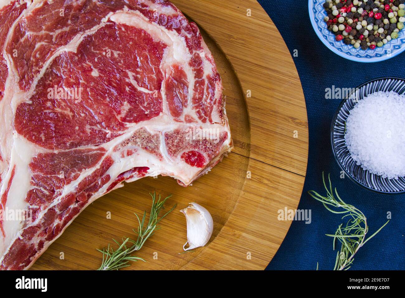 Slice of raw beef meat on the table with rosemary and other spices, rib ...