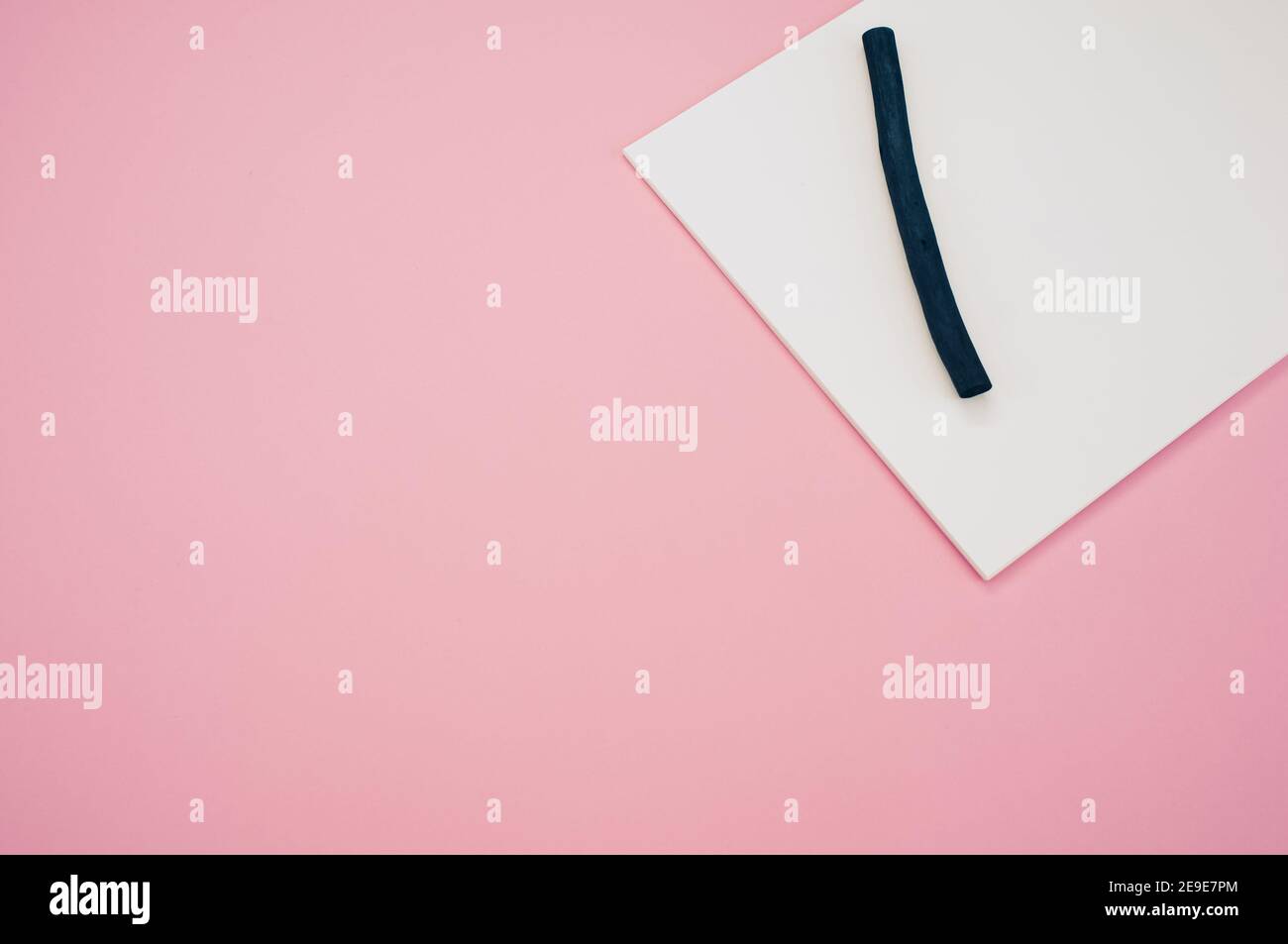 Top view closeup of a black piece of paper and a piece of black string ...