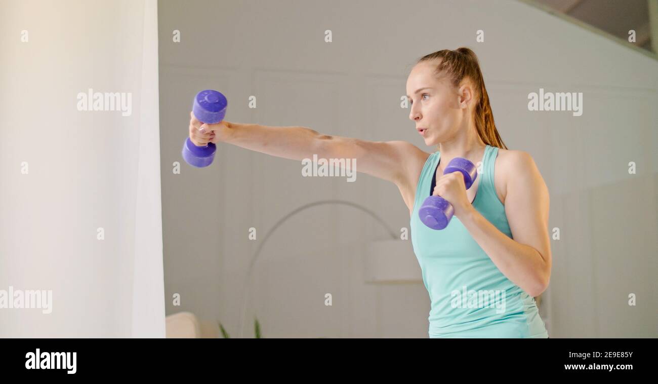 Cheerful Lively Girl Holding a Small Pink Dumbbell and Doing Exercises ...
