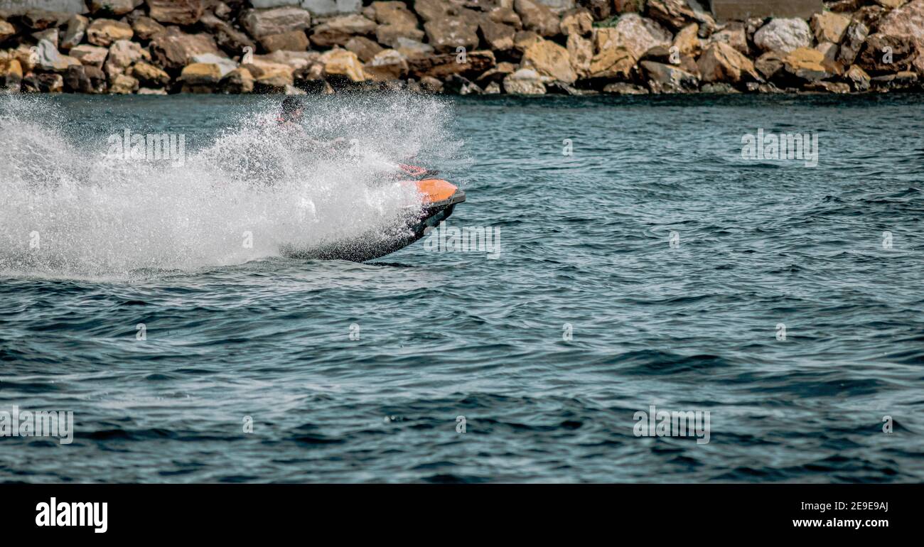 Person speeding on a jet ski on a wavy sea water surface Stock Photo ...