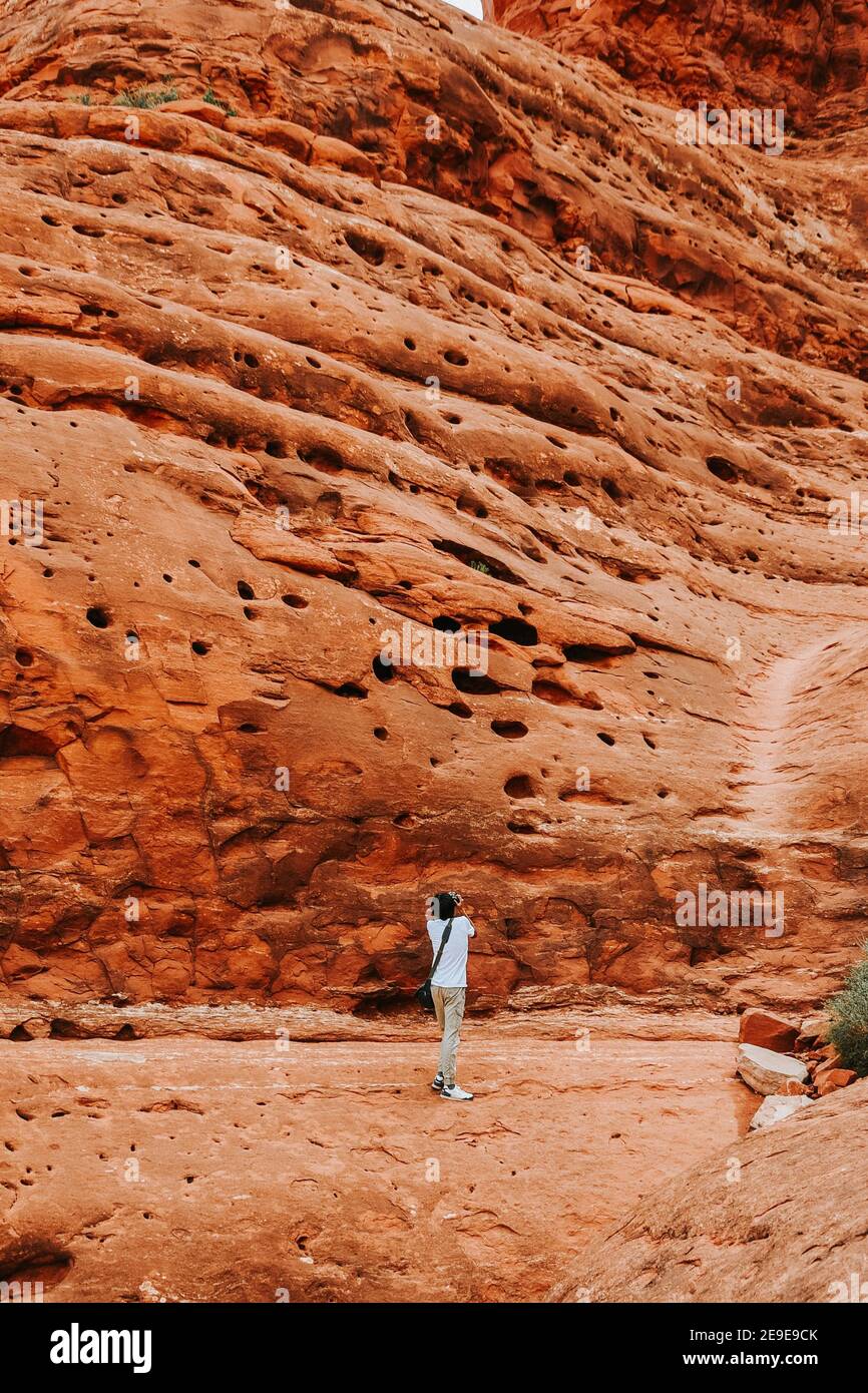 Back view of a photographer taking a picture of an immense red ...