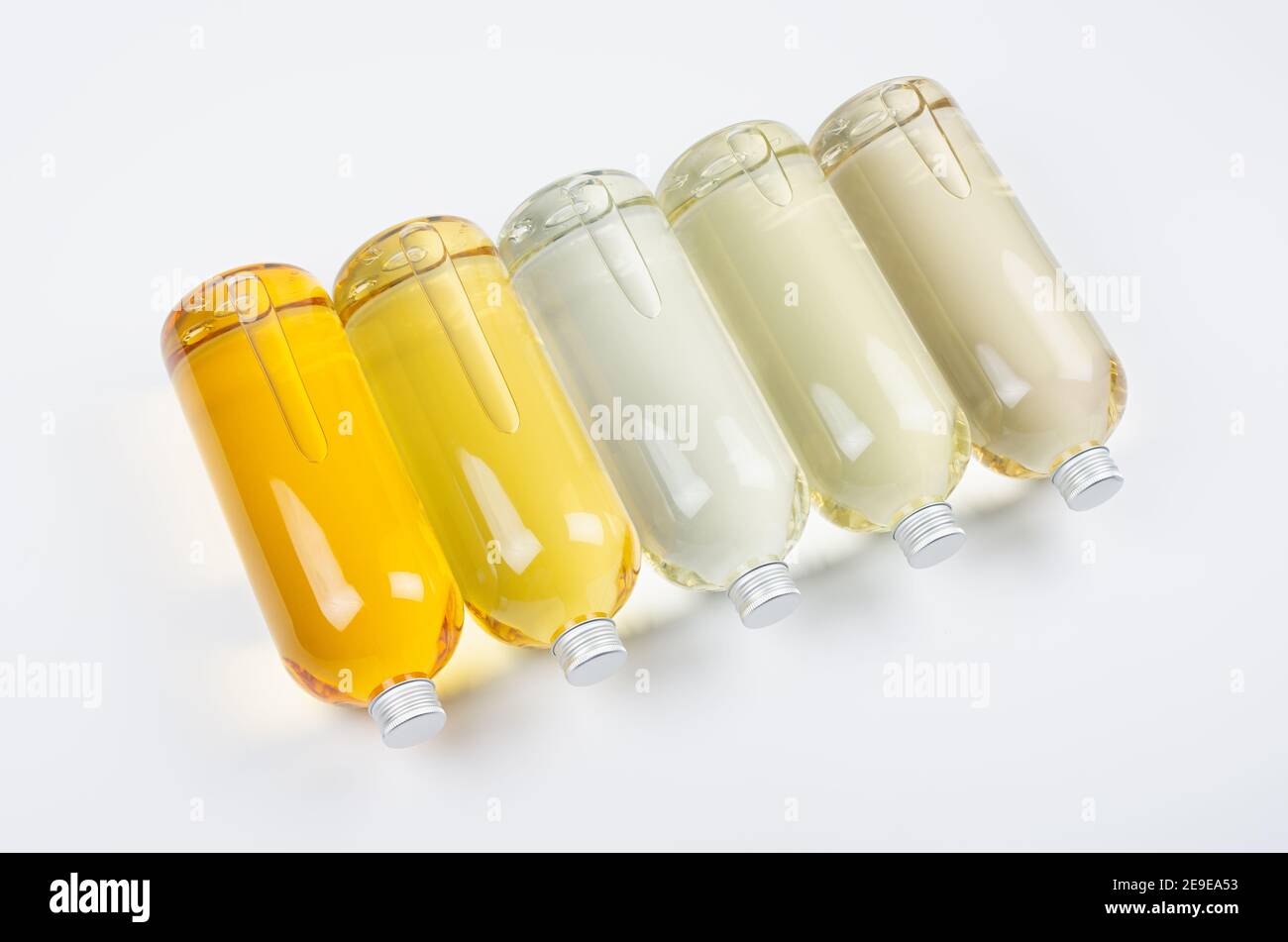 Collection transparent lying bottles with different pale colors liquid ...